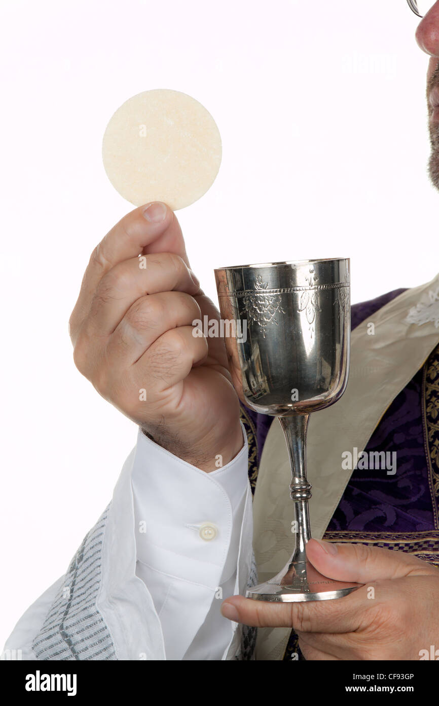 a catholic priest with a chalice and paten at communion Stock Photo - Alamy