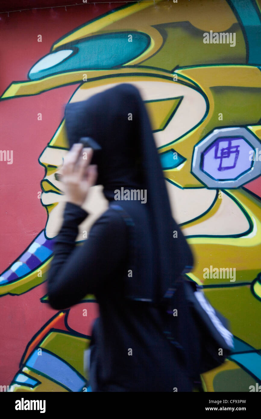 grafitti wall woman wearing burqa on mobile phone Haji street Indian ...