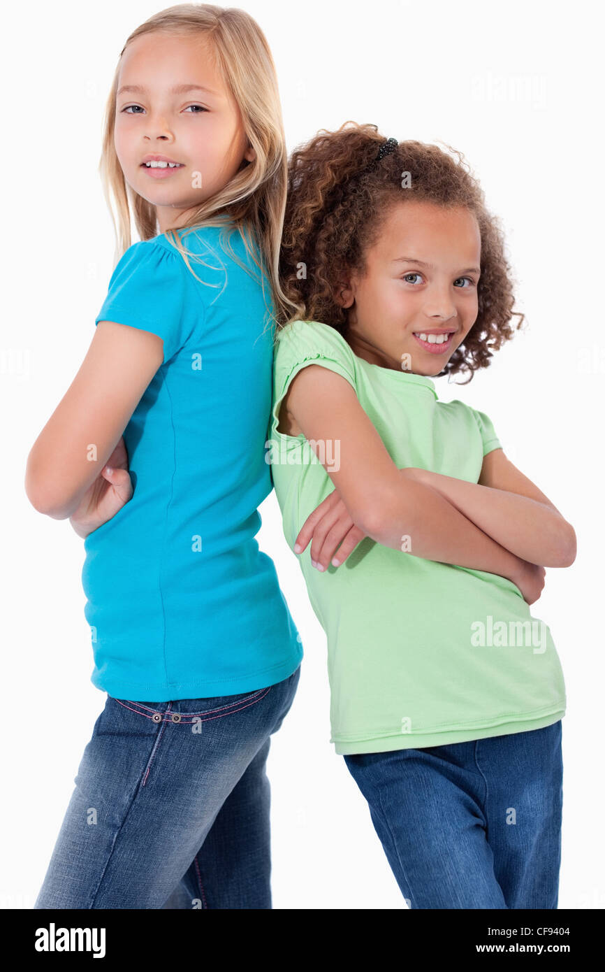 Portrait of happy girls standing back to back Stock Photo - Alamy