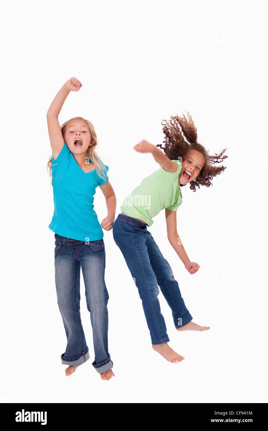 Portrait of cheerful girls jumping Stock Photo - Alamy
