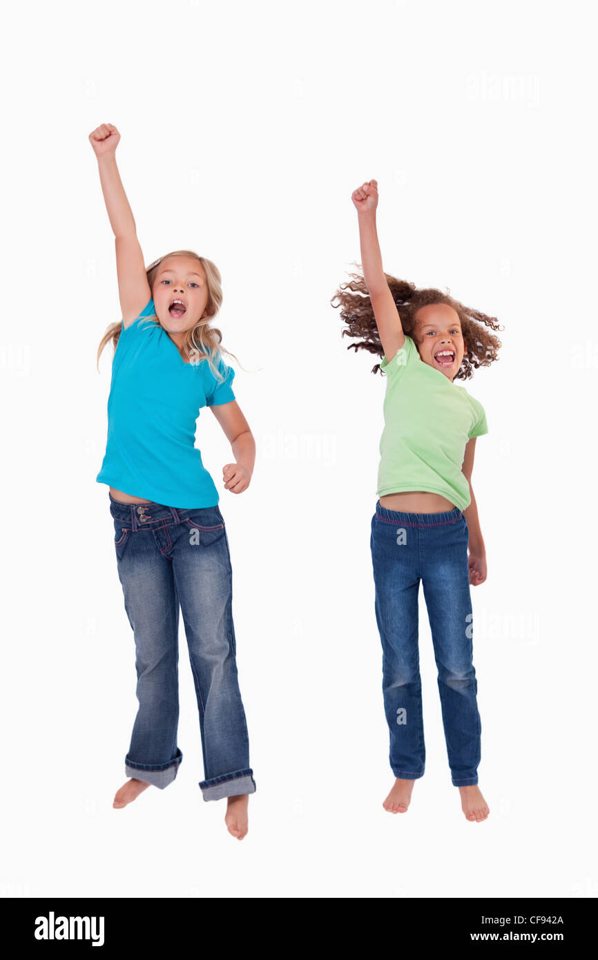 Portrait of girls jumping with their fists up Stock Photo - Alamy