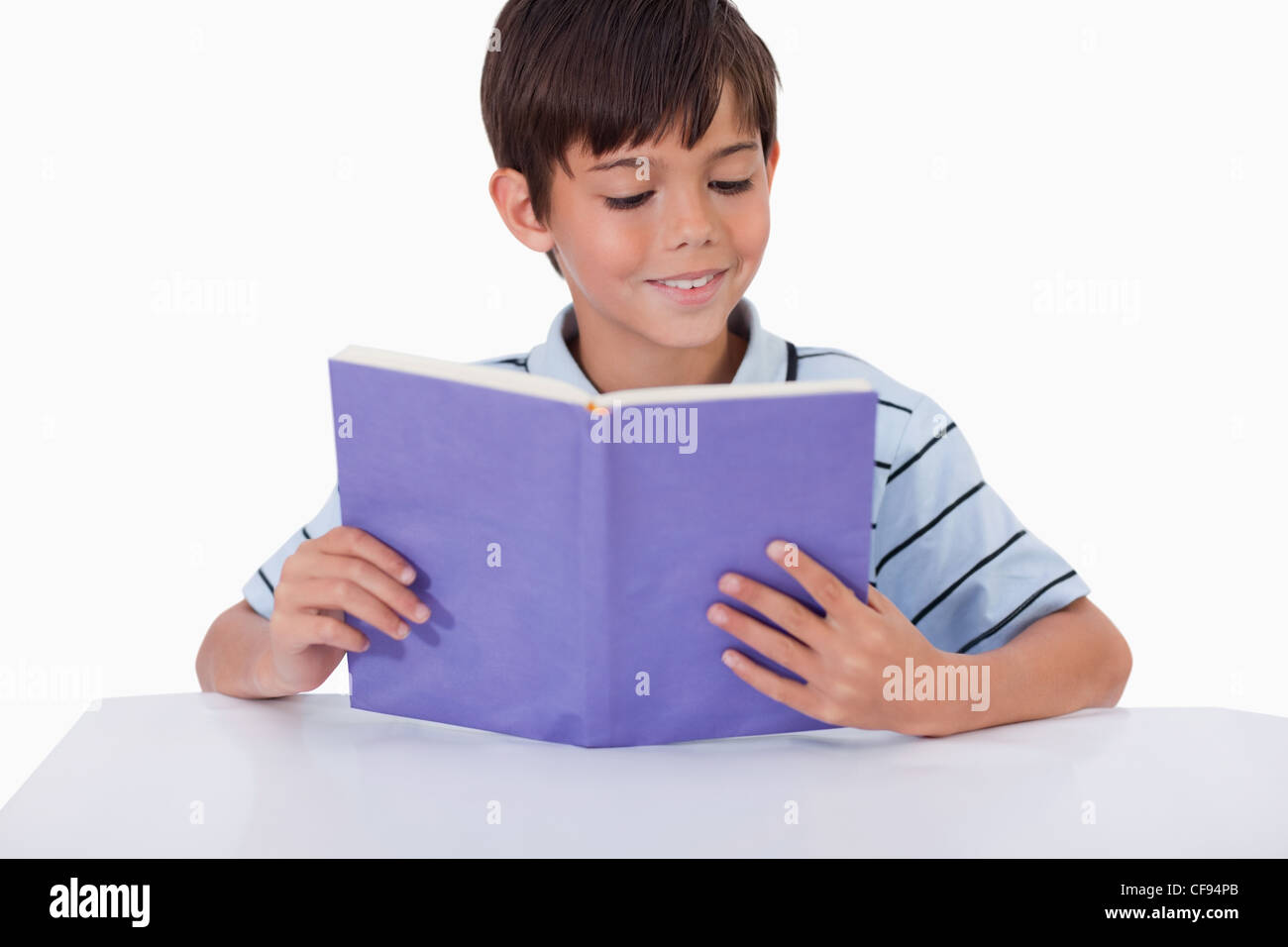 Smiling boy reading a book Stock Photo - Alamy