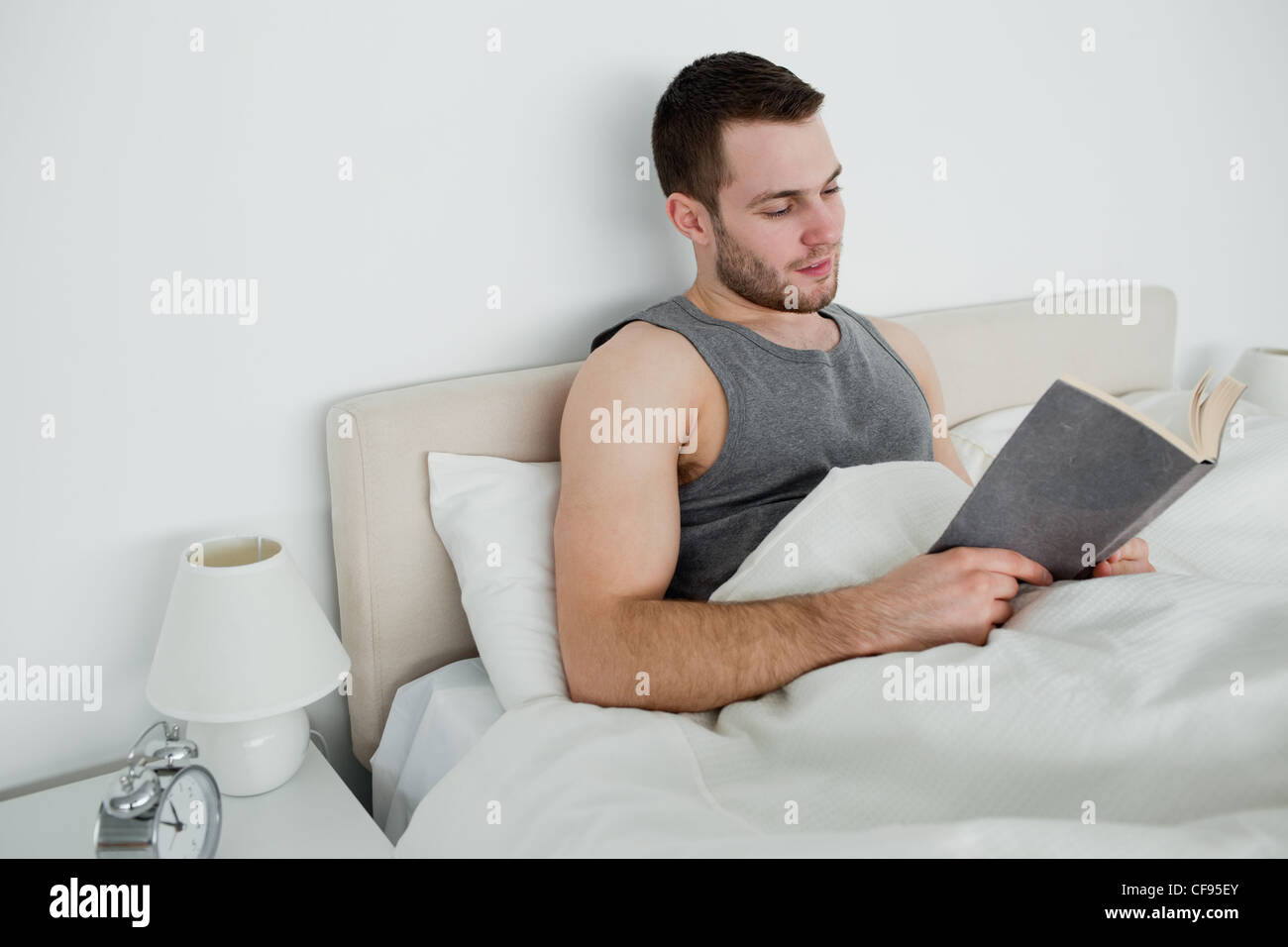 Young man reading a novel Stock Photo - Alamy
