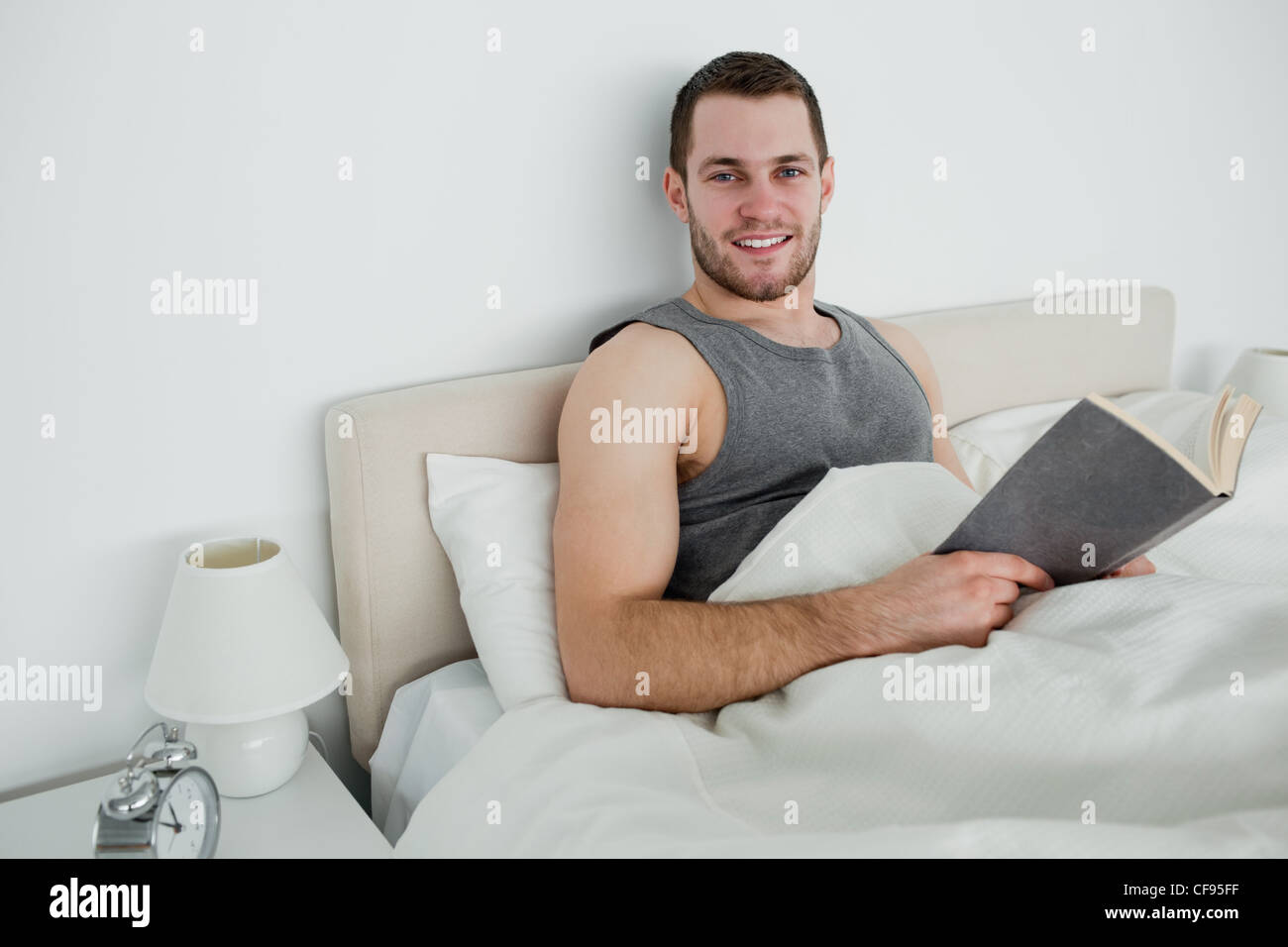Smiling man reading a novel Stock Photo - Alamy