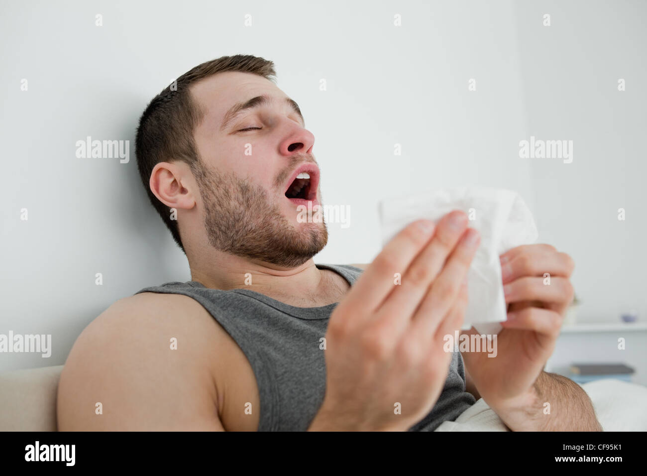 Sick man sneezing Stock Photo - Alamy