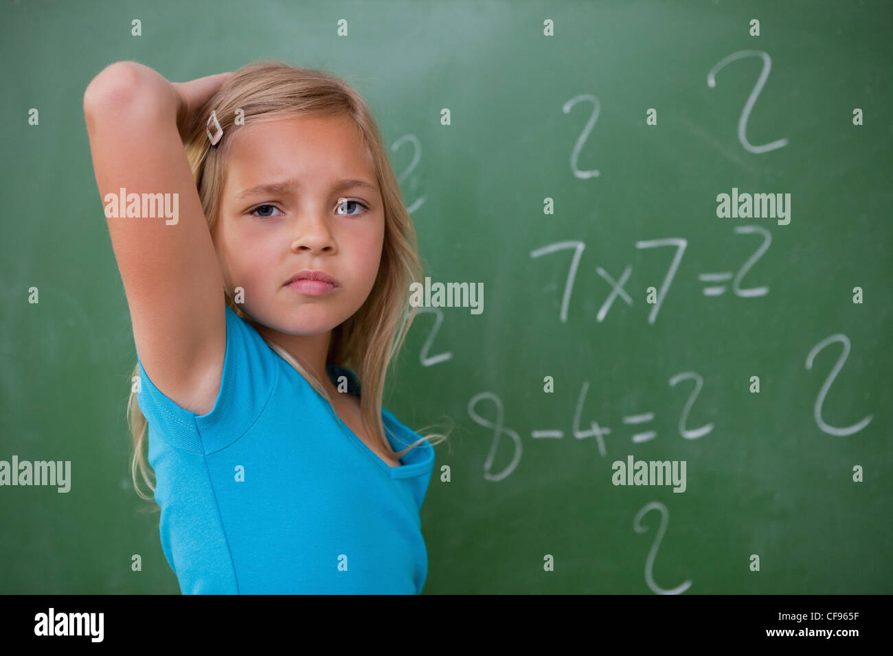 Schoolgirl thinking while scratching the back of her head Stock Photo ...