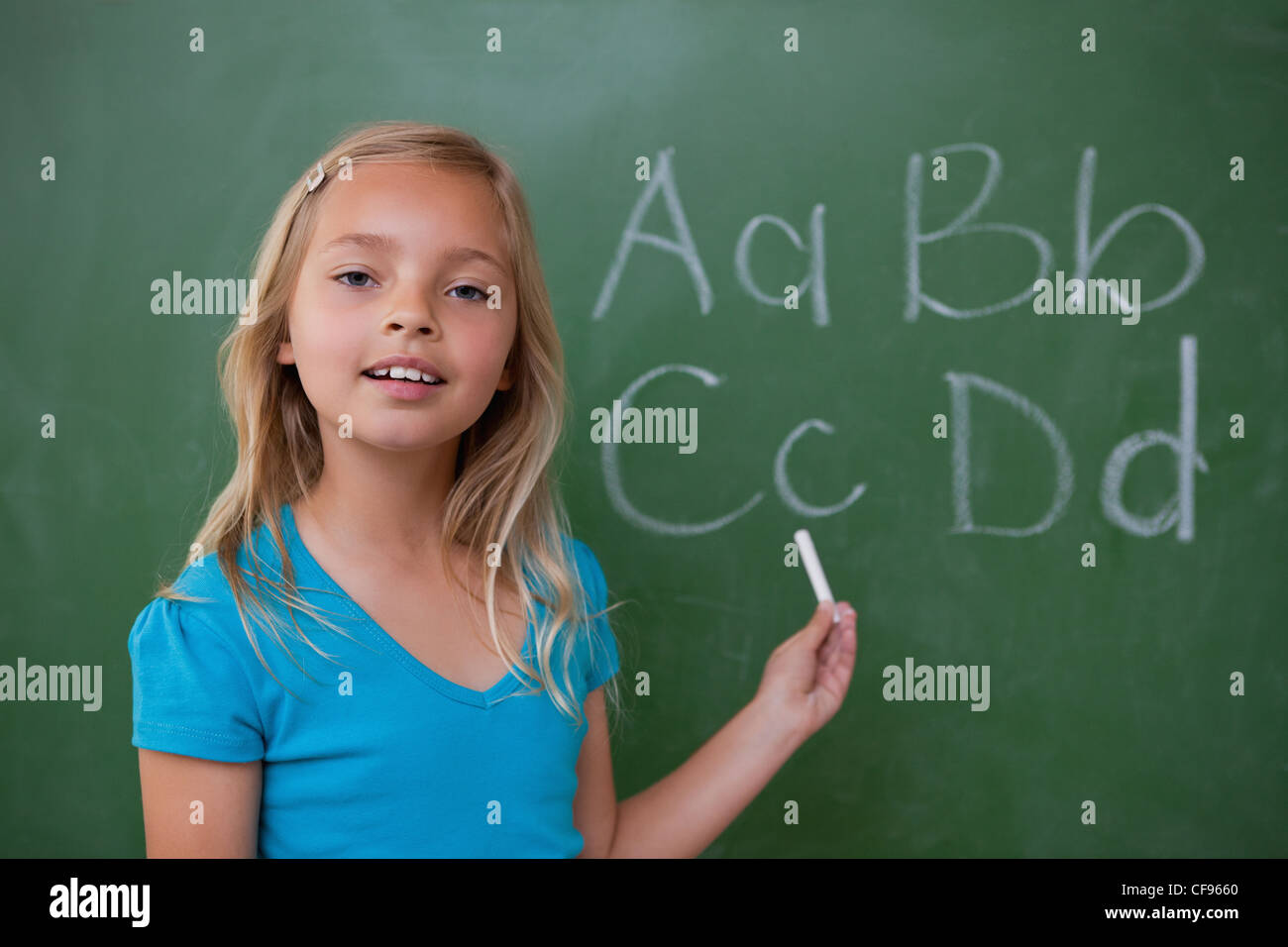 Smiling schoolgirl showing letters Stock Photo - Alamy
