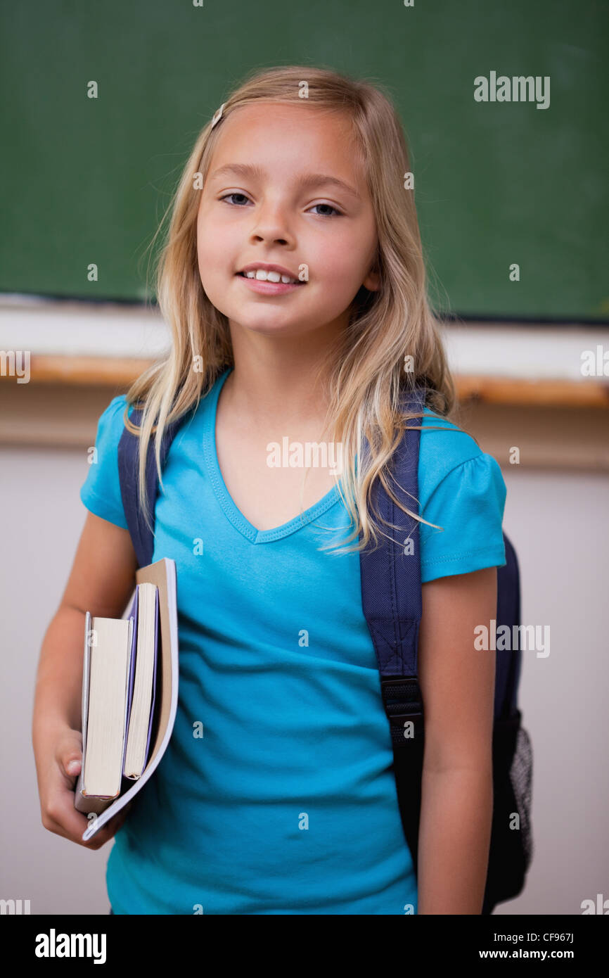 Portrait of a blonde schoolgirl holding her books Stock Photo - Alamy