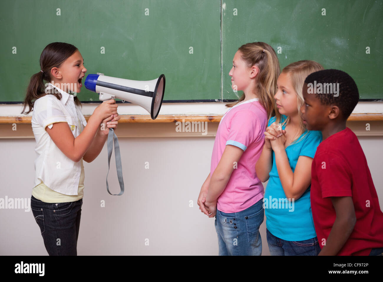 Angry schoolgirl screaming through a megaphone to her classmates Stock ...