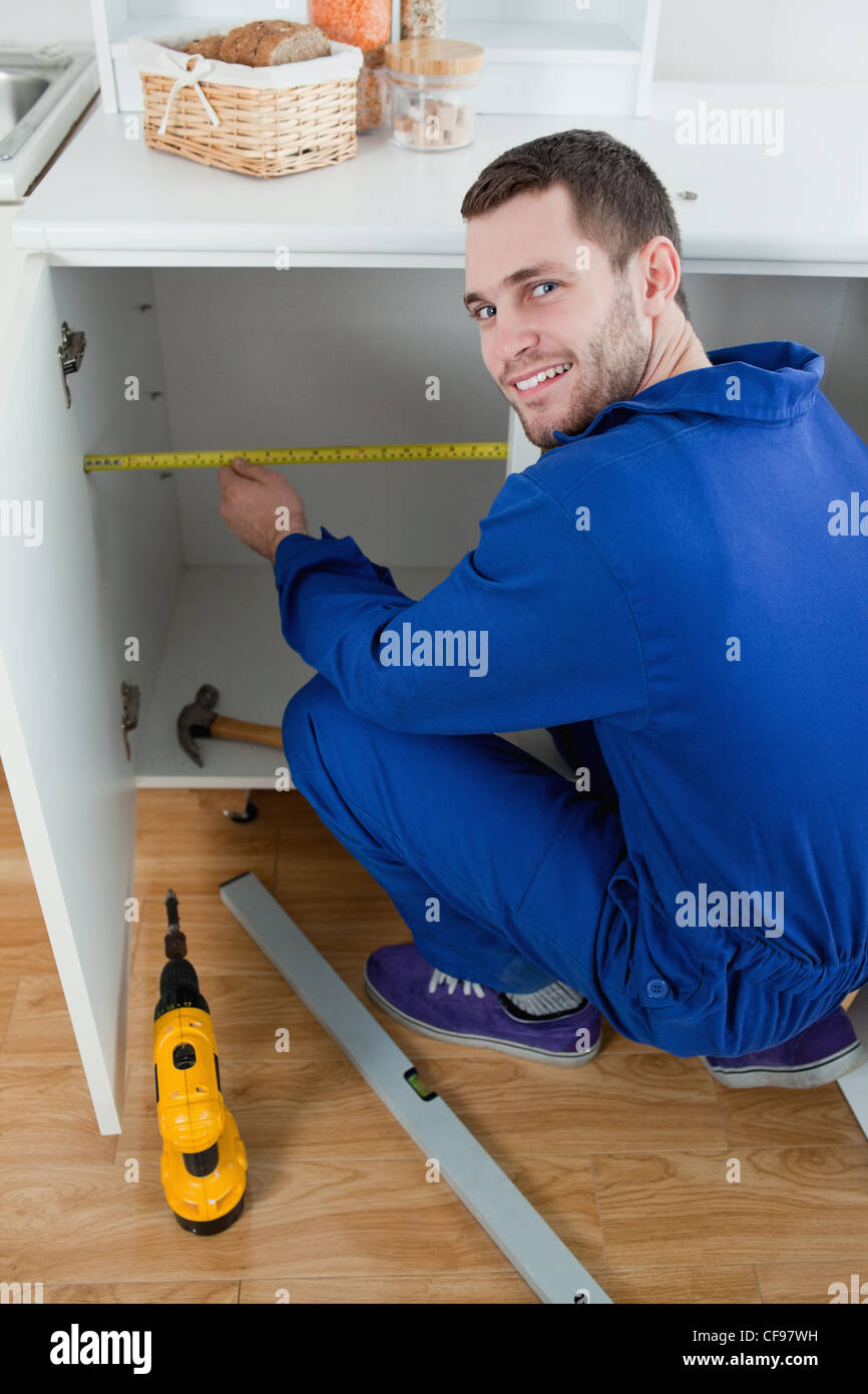 Portrait of a smiling repair man measuring something Stock Photo - Alamy