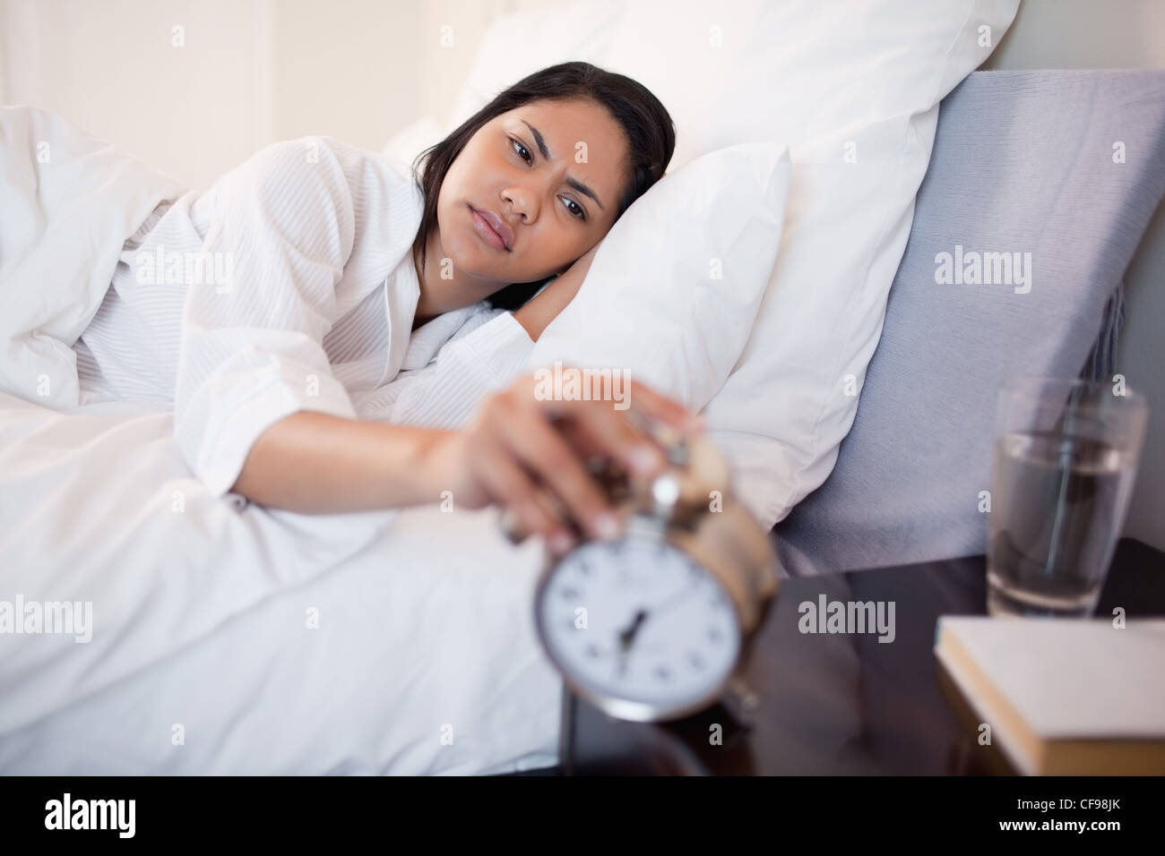 Woman annoyed by ringing alarm clock Stock Photo - Alamy