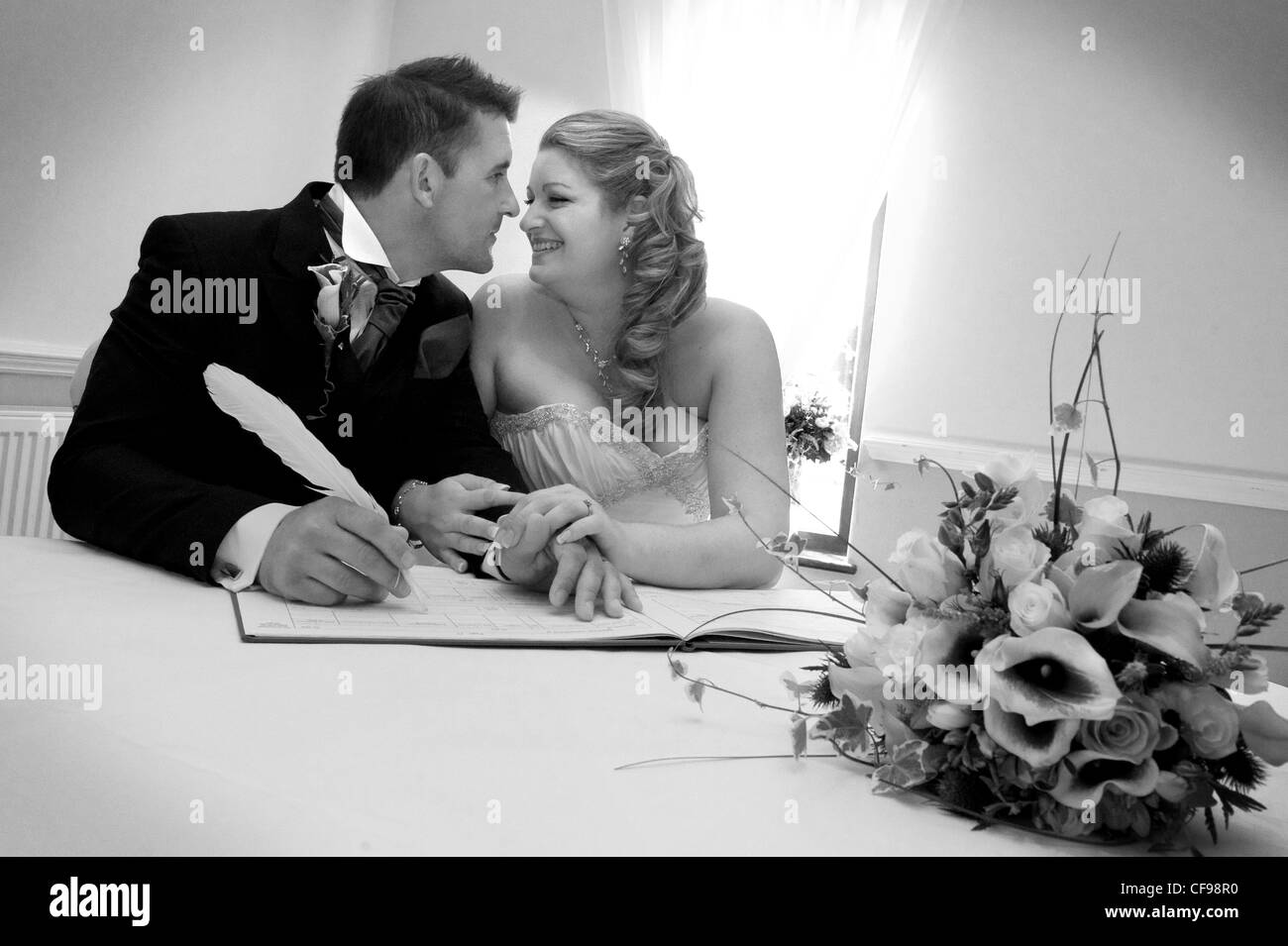 bride and groom signing wedding register Stock Photo - Alamy
