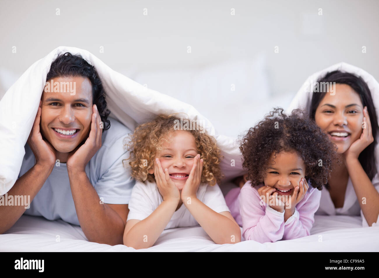 Happy family hiding under the blanket Stock Photo - Alamy