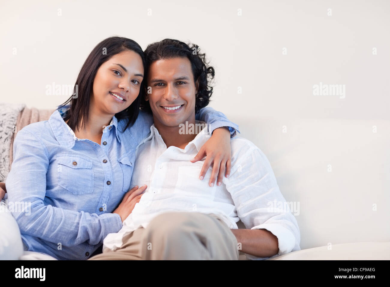 Couple on the sofa hugging Stock Photo - Alamy