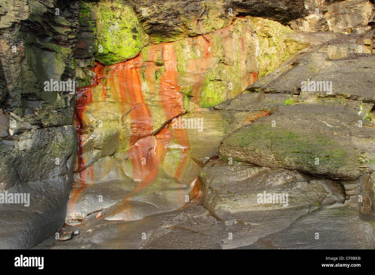 Rock face showing iron being washed out by ground water and staining ...