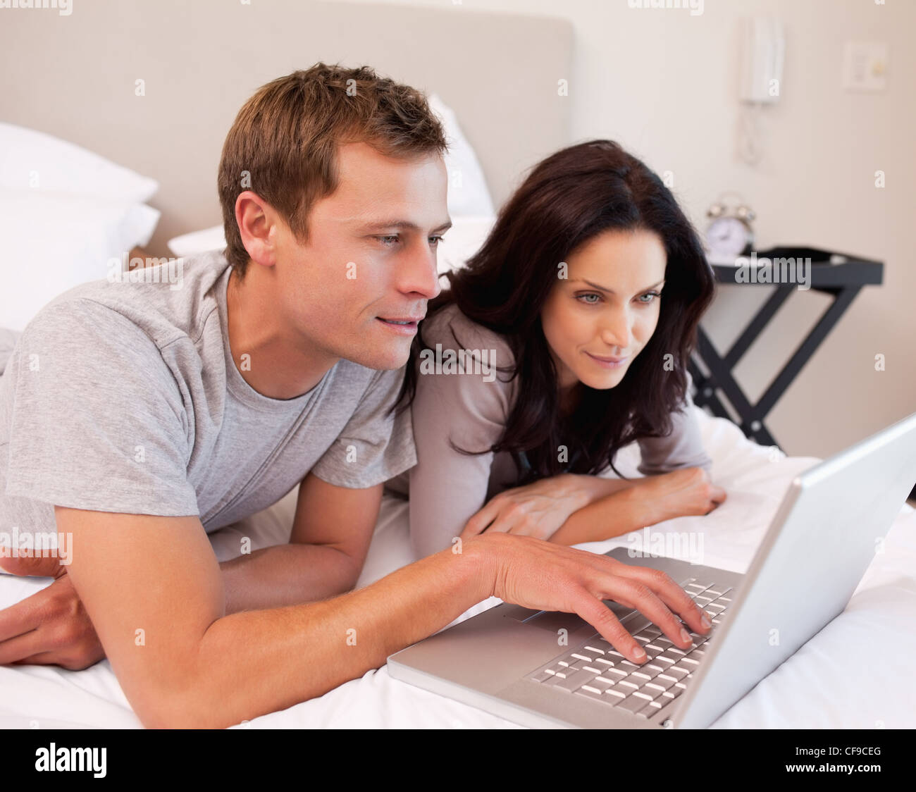 Couple using notebook together in the bedroom Stock Photo - Alamy