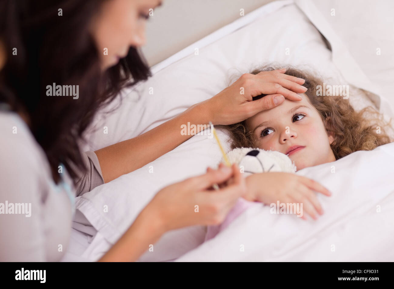 Mother taking care of her sick daughter Stock Photo - Alamy
