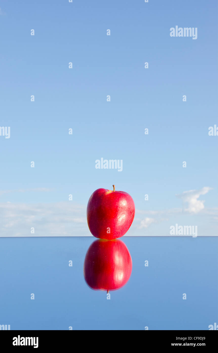 one red apple with reflection on mirror and sky Stock Photo - Alamy