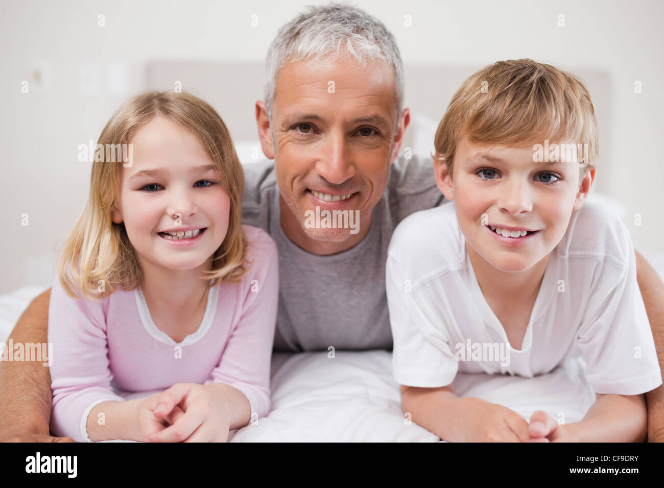 Smiling siblings and their father posing Stock Photo - Alamy