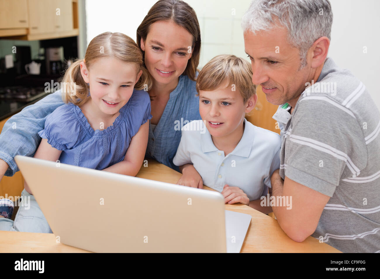 Lovely family using a laptop Stock Photo - Alamy