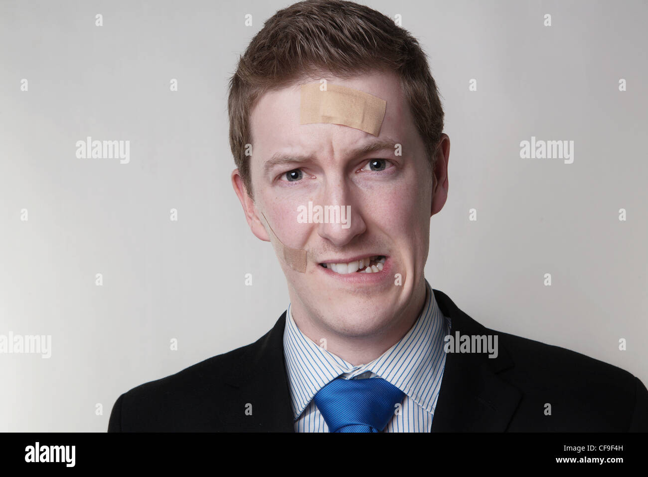 businessman with plasters on his face looking hurt and unhappy Stock ...