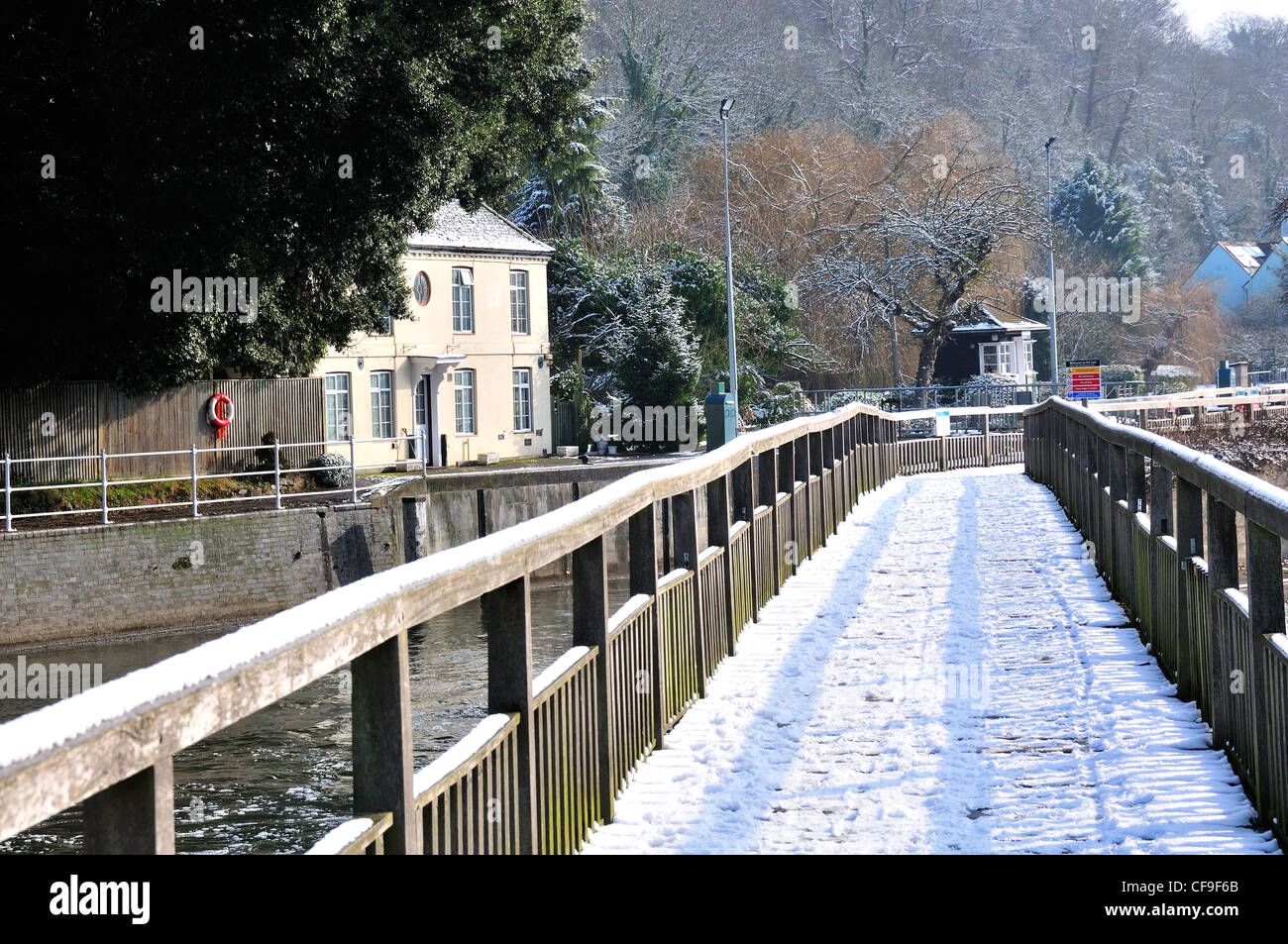 Lock keeper's house with snow covered footbridge over River Thames, at ...