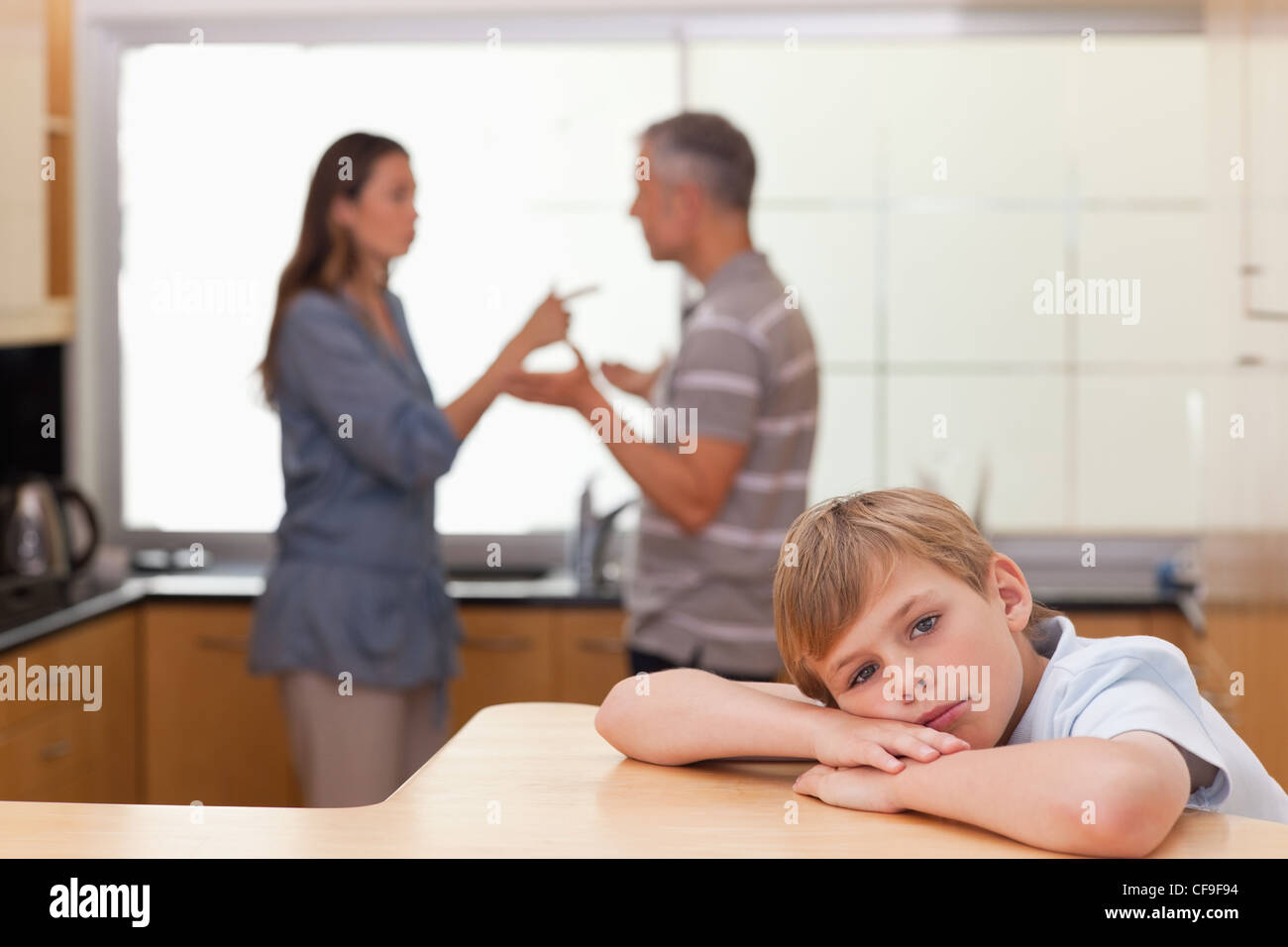 Sad little boy hearing his parents arguing Stock Photo - Alamy