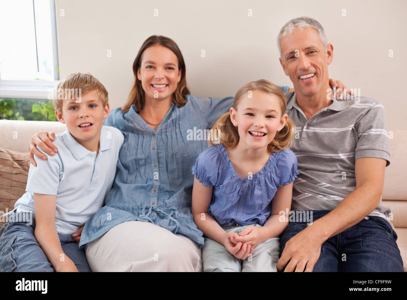 Family sitting on a sofa Stock Photo - Alamy