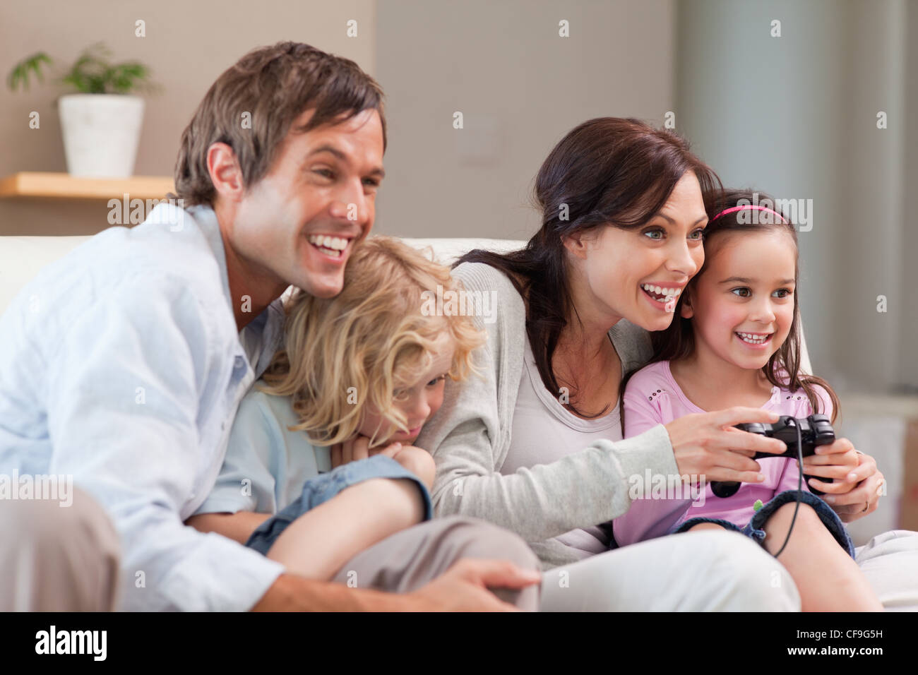 Delighted family playing video games together Stock Photo - Alamy