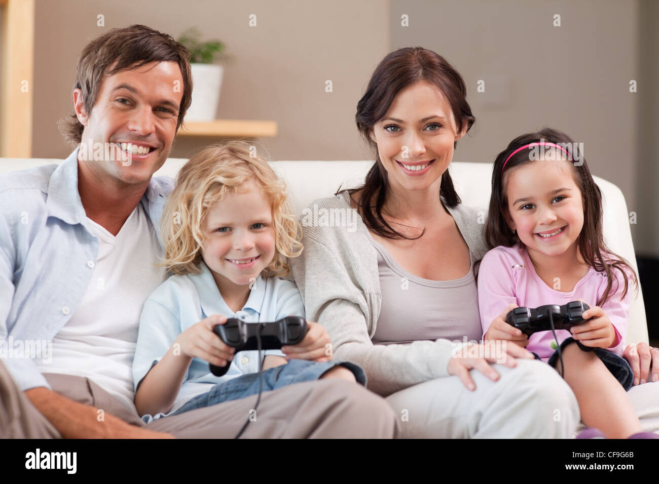 Smiling family playing video games together Stock Photo - Alamy