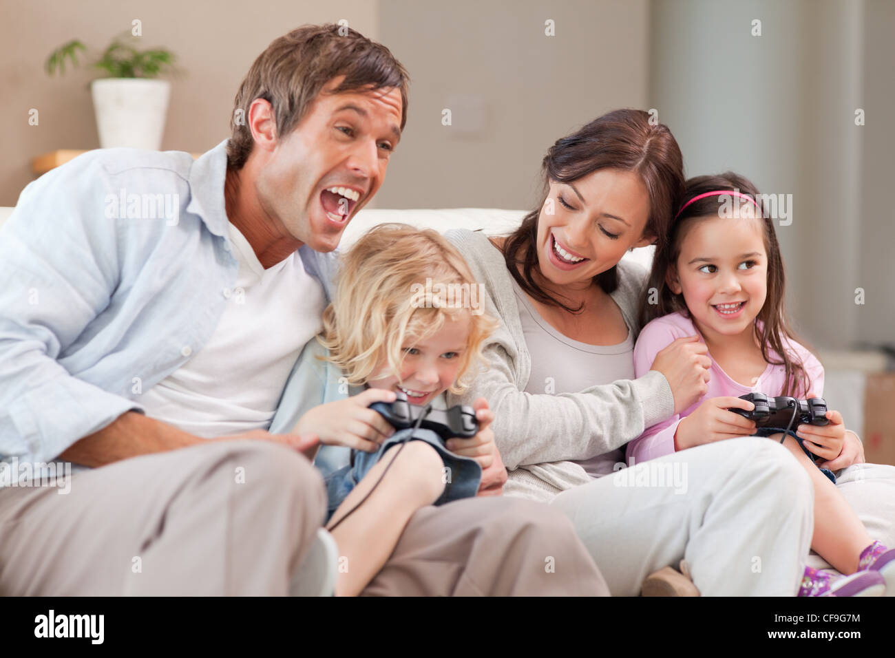 Laughing family playing video games Stock Photo - Alamy