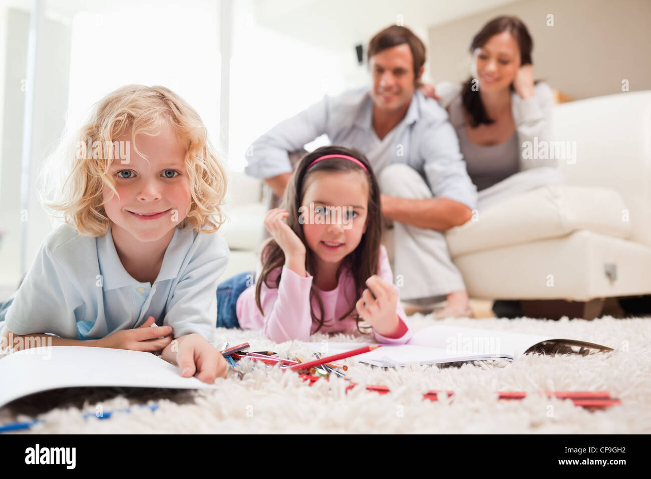 Cute siblings drawing while their parents are in the background Stock ...
