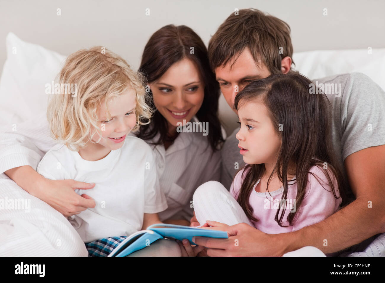 Family reading a book Stock Photo - Alamy