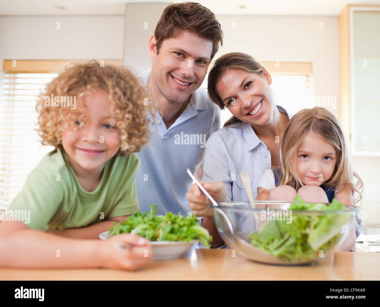 Smiling family preparing a salad together Stock Photo - Alamy