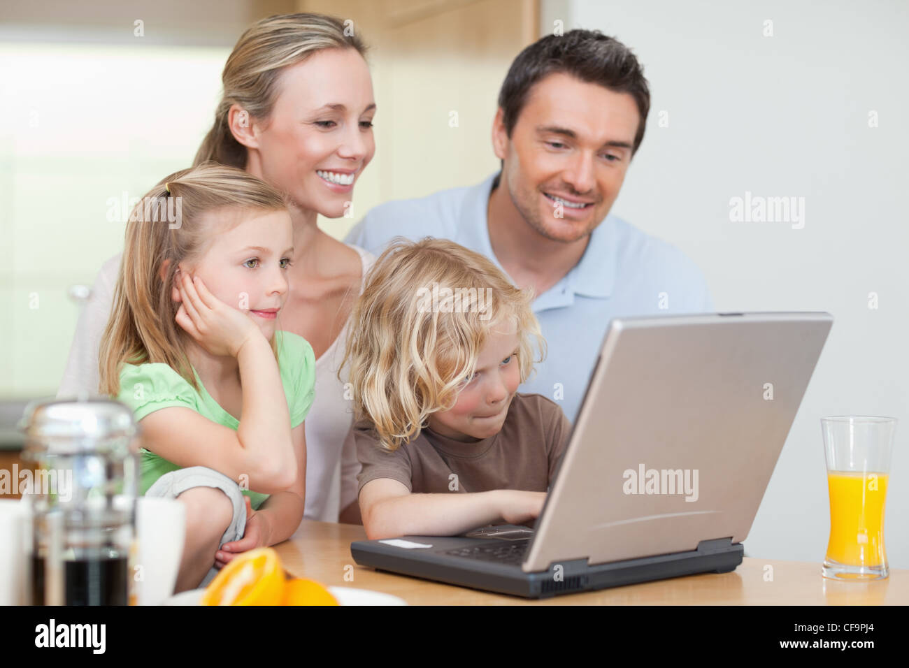Family using the internet in the kitchen Stock Photo - Alamy