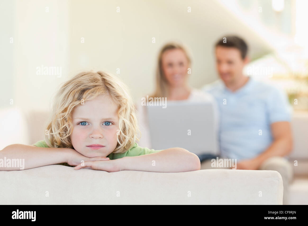 Sad boy with parents in the background Stock Photo - Alamy