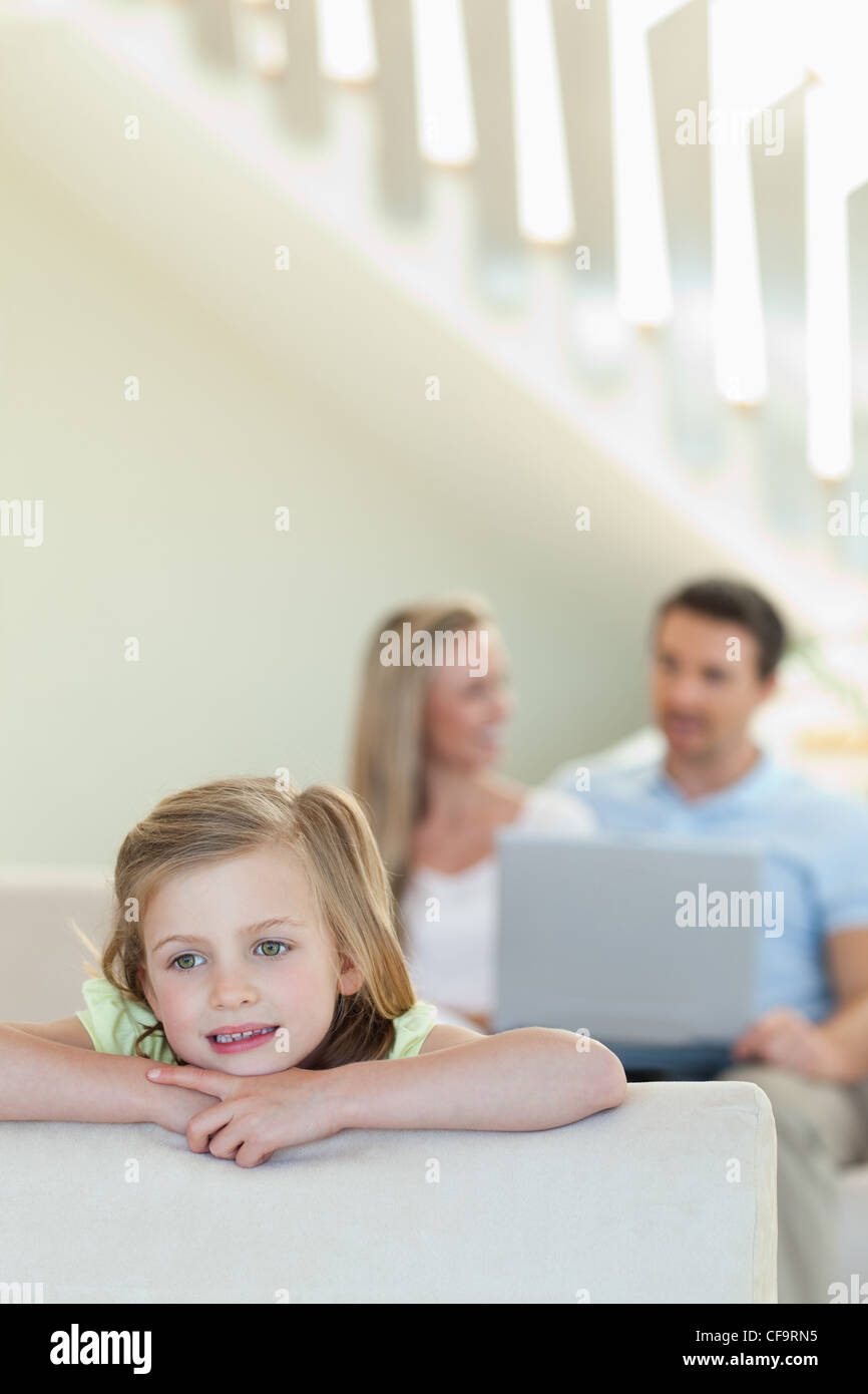 Girl in thoughts with parents behind her Stock Photo - Alamy
