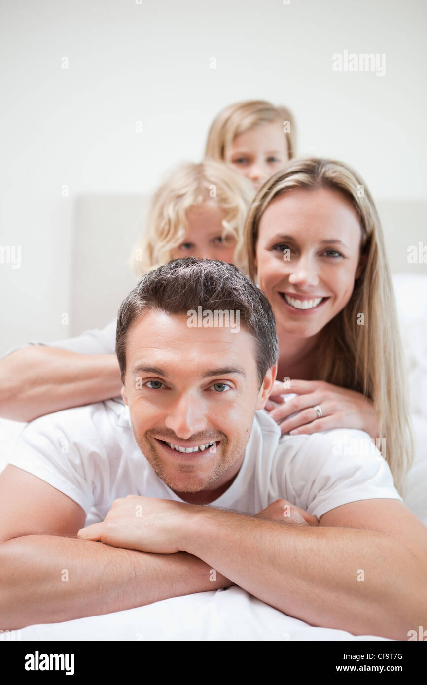 Smiling family lying in bed hi-res stock photography and images - Alamy