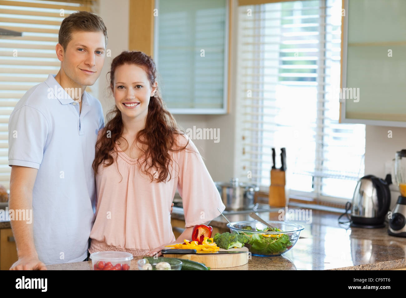 Couple standing behind kitchen counter Stock Photo - Alamy