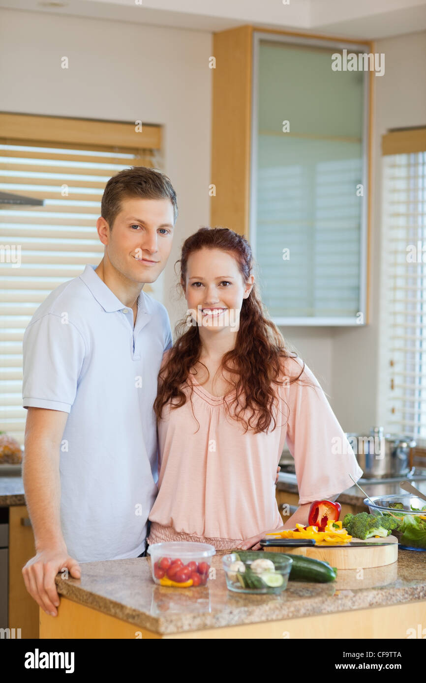 Young couple standing behind kitchen counter Stock Photo - Alamy
