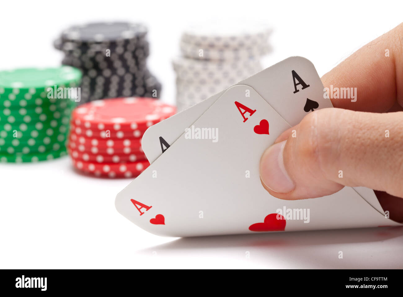 Poker: player shows pocket aces with poker chips in the back on white ...
