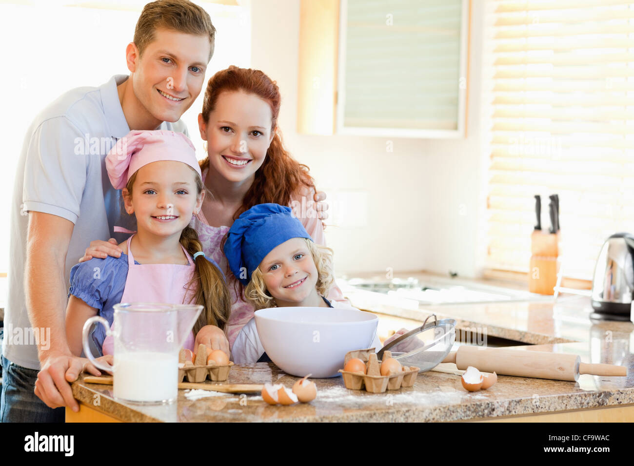 Family with baking ingredients behind the kitchen counter Stock Photo ...