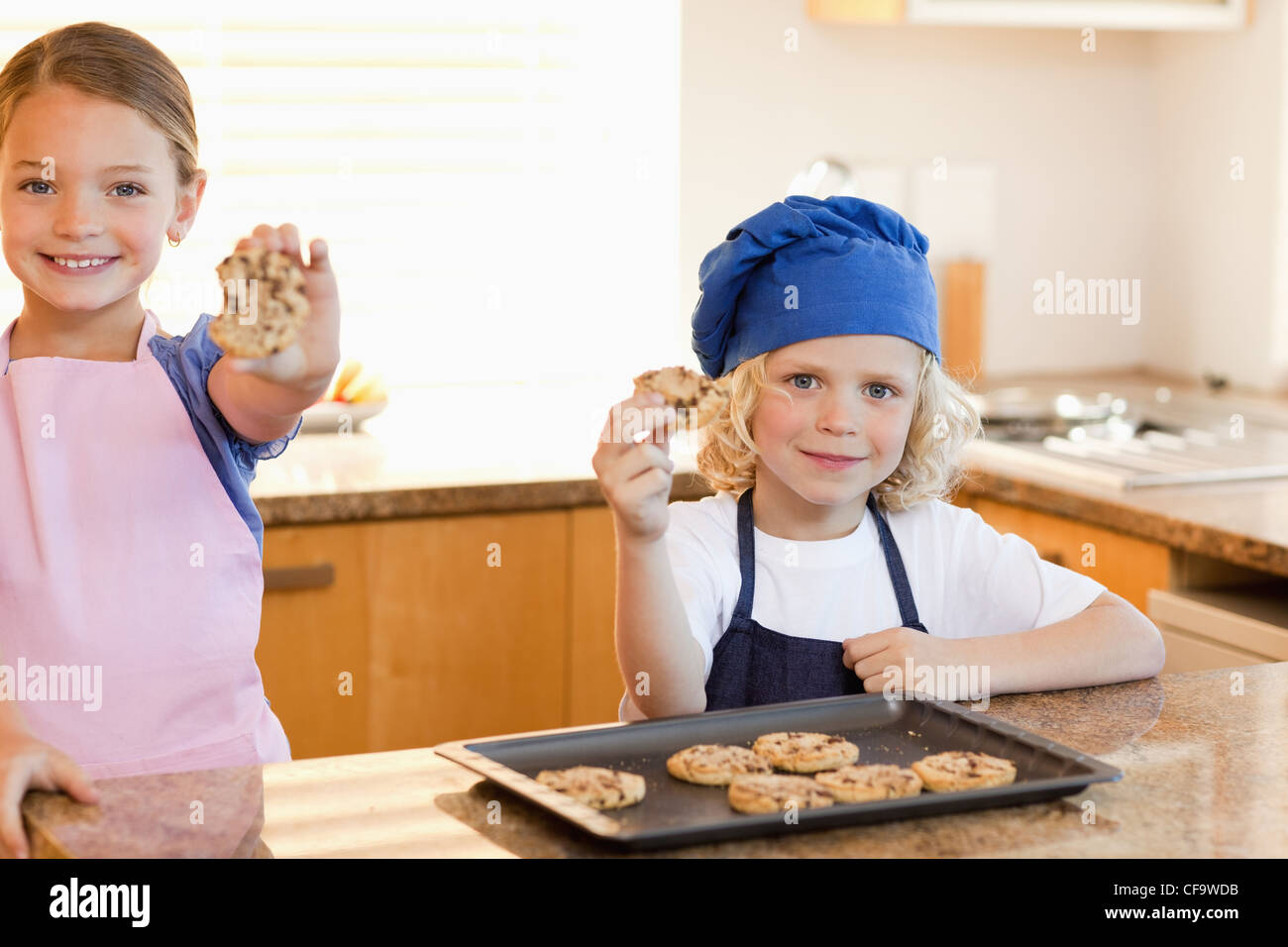 Siblings holding their cookies Stock Photo - Alamy