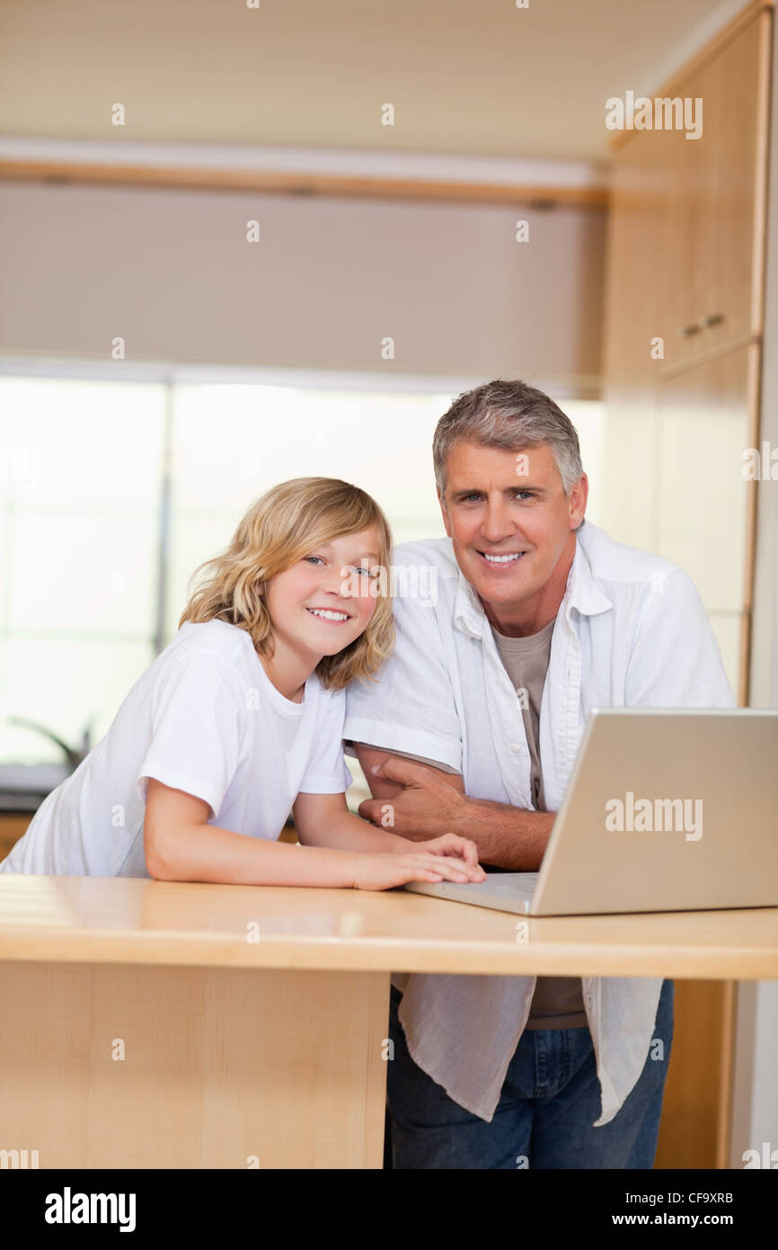 Father and son with laptop in the kitchen Stock Photo - Alamy