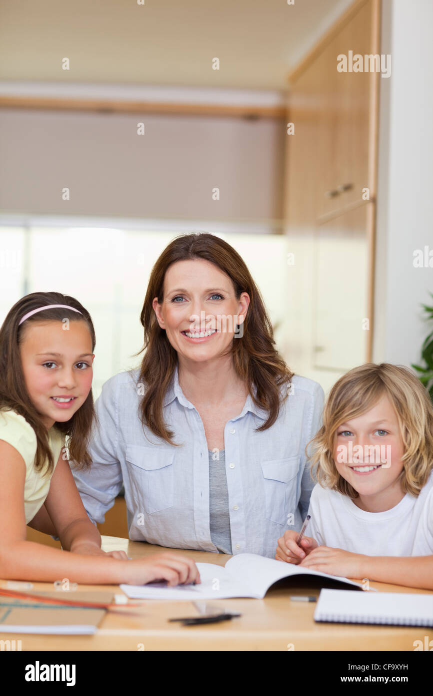 Mother helping children with homework Stock Photo - Alamy
