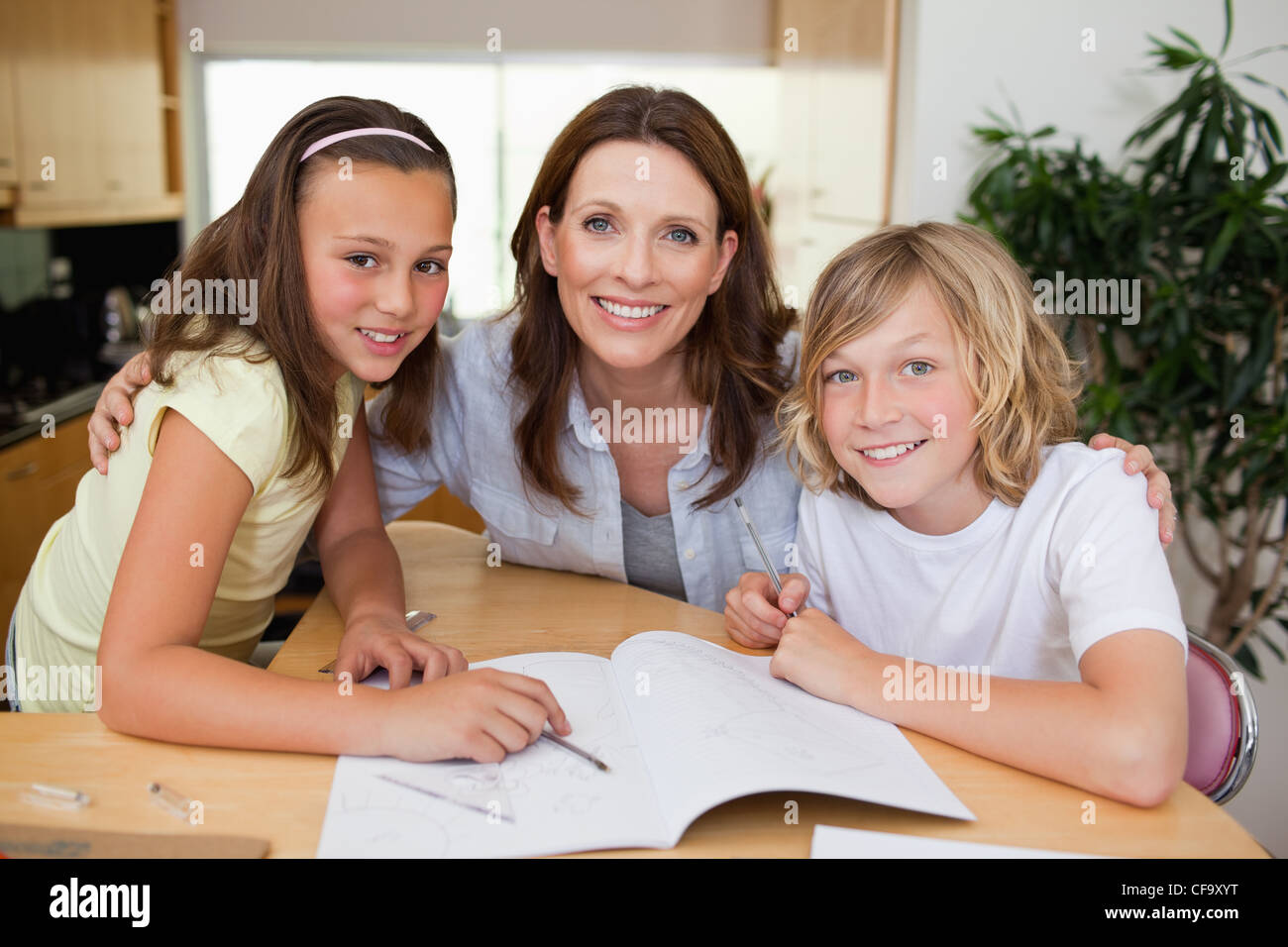Mother helping her children with homework Stock Photo - Alamy
