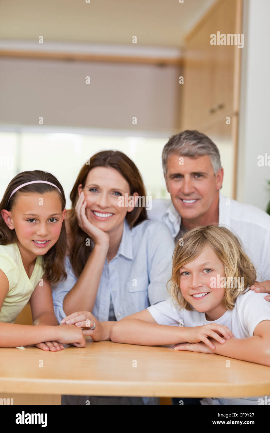 Smiling family behind kitchen table Stock Photo - Alamy