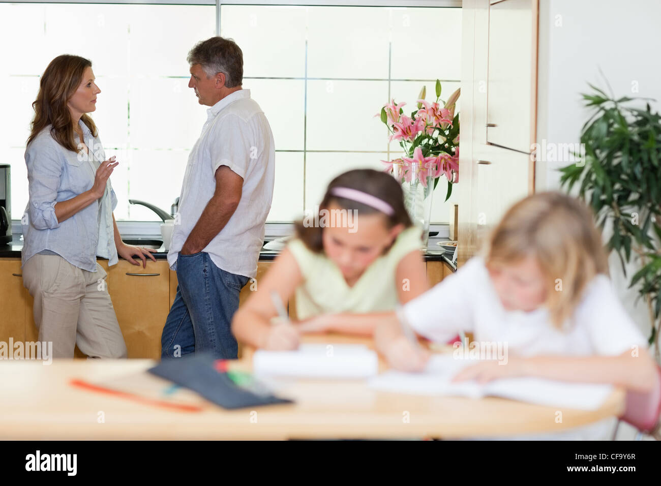 Parents talking with children doing homework in front of them Stock ...