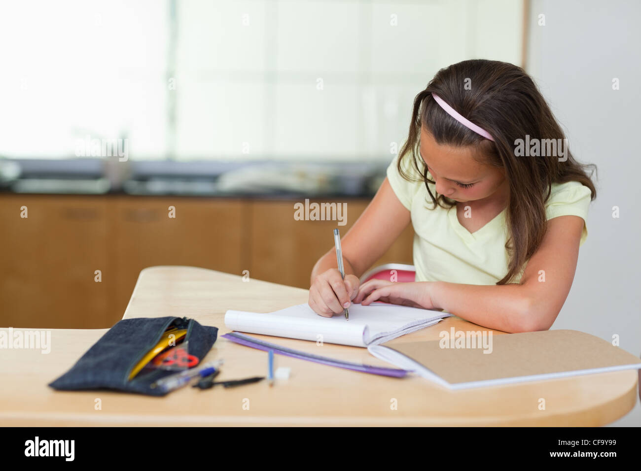 Girl doing homework in the kitchen Stock Photo - Alamy