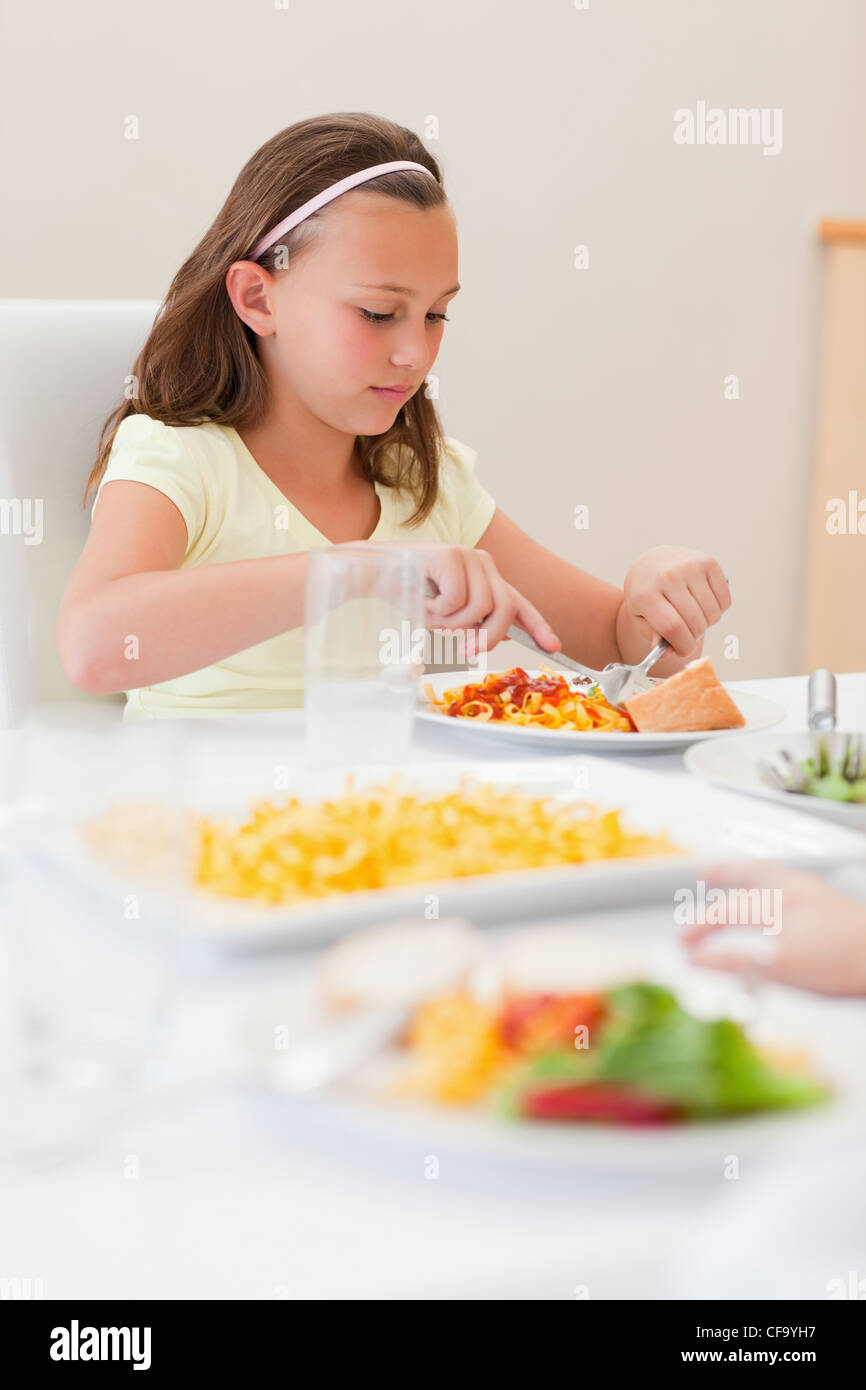 Girl eating at dinner table Stock Photo - Alamy